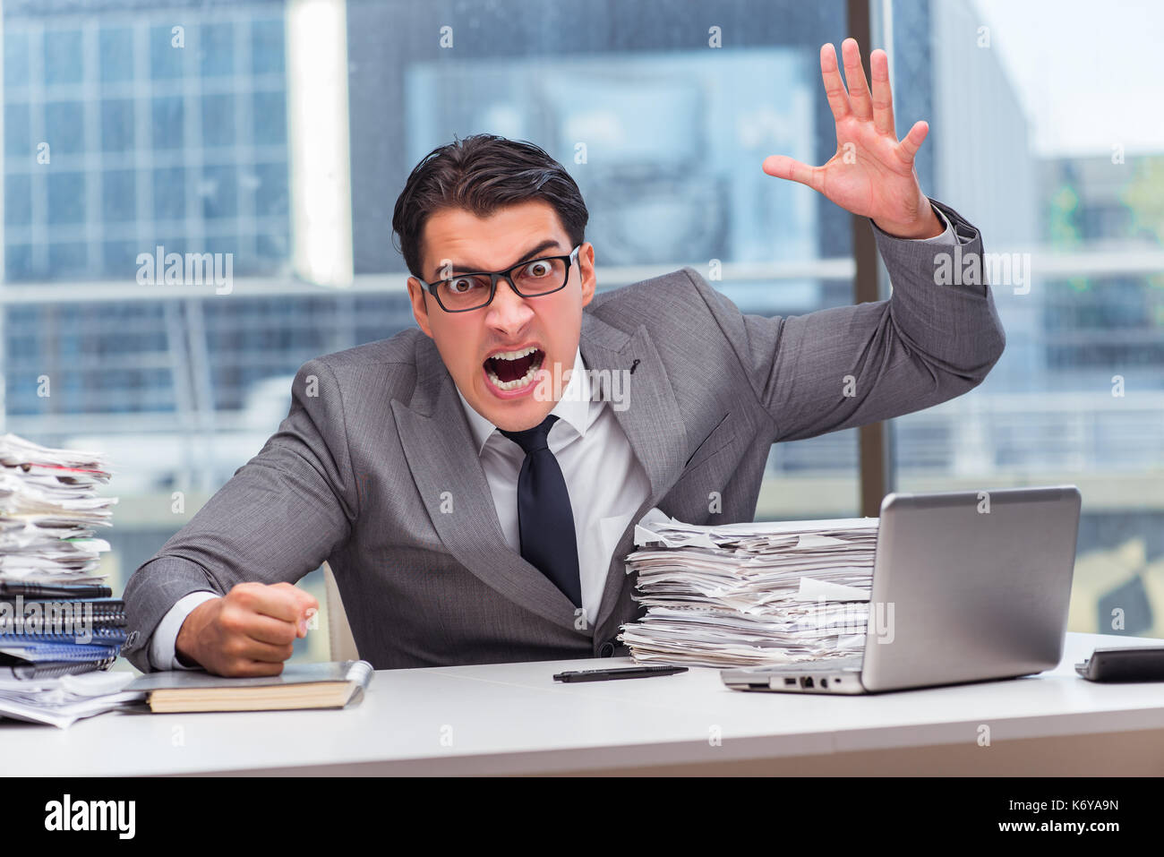 Angry businessman with too much work in office Stock Photo - Alamy