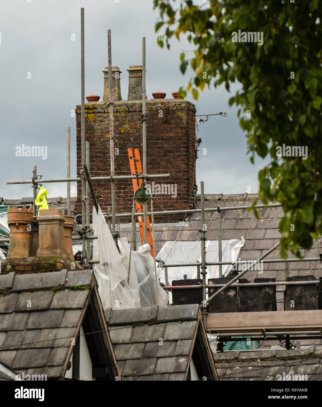 Scaffolding with ladder slate roof and brick chimney Stock Photo - Alamy