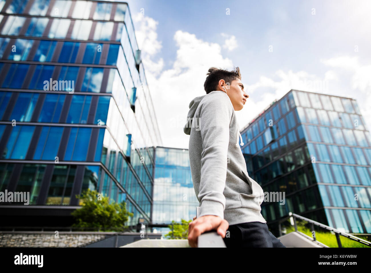 Runner in the city resting in front of glass buildings Stock Photo - Alamy