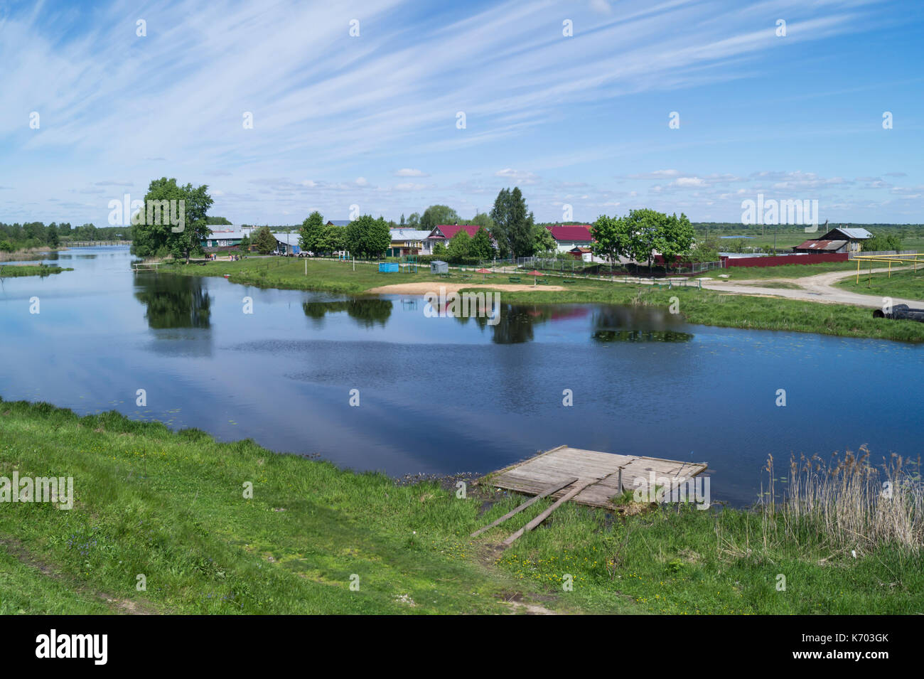 Rural landscape with river on background blue sky with white cloud ...