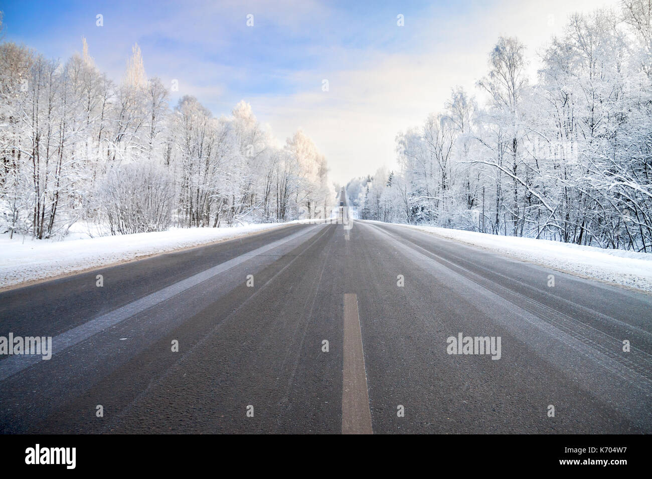 beautiful winter landscape with asphalt road,forest and blue sky ...