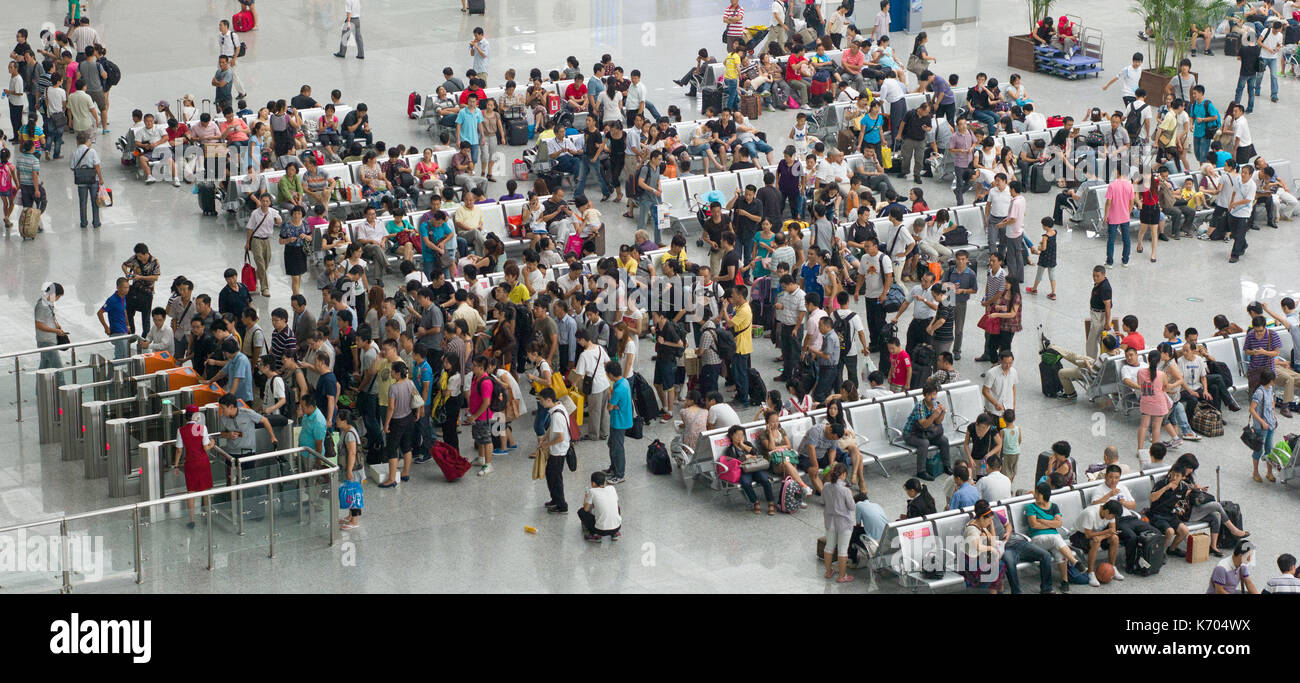 Passengers queue at electronic gates in waiting hall to have their ...