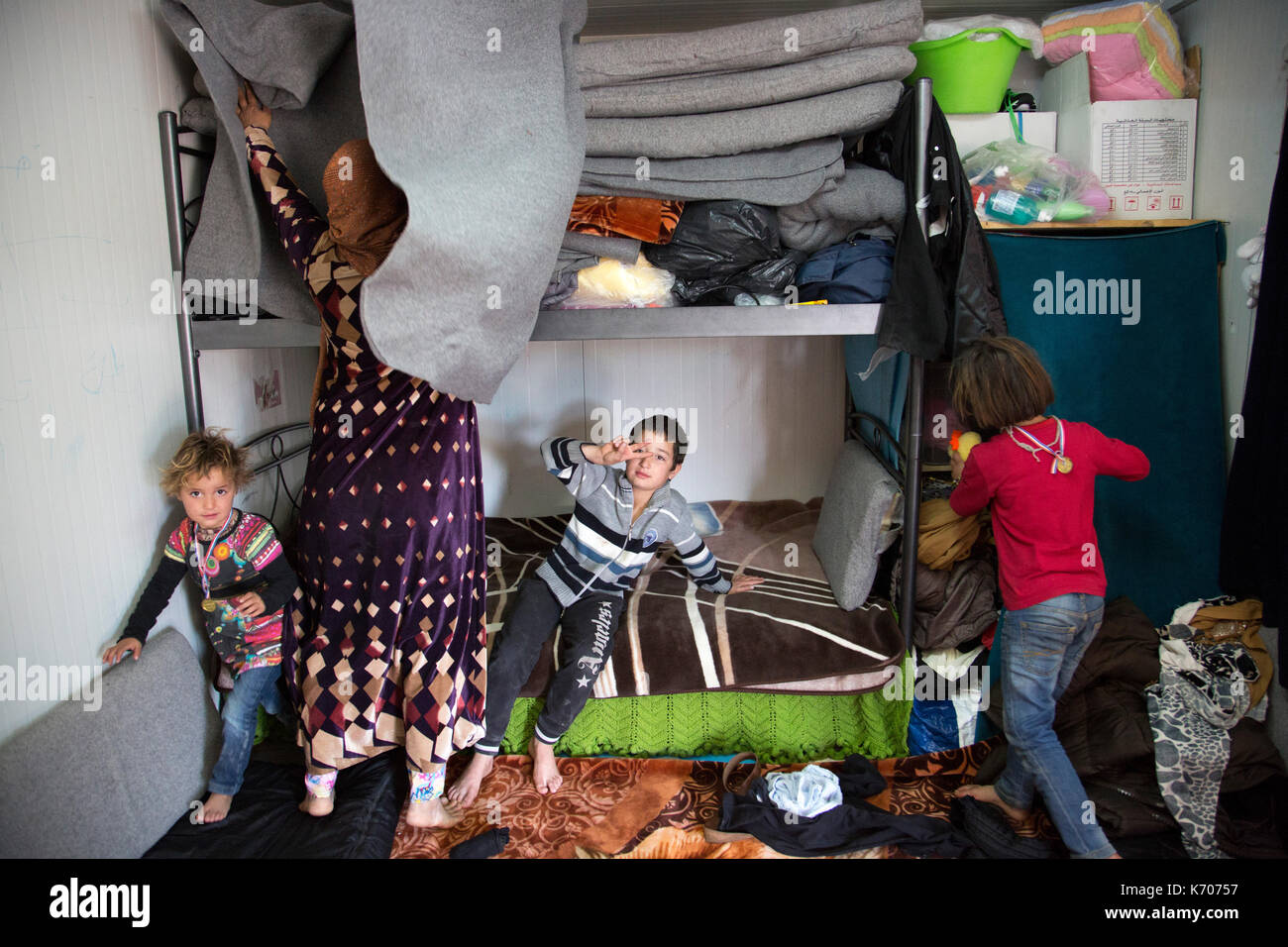 A Syrian refugee mother, tidies her prefabricated 'Isobox' house by ...