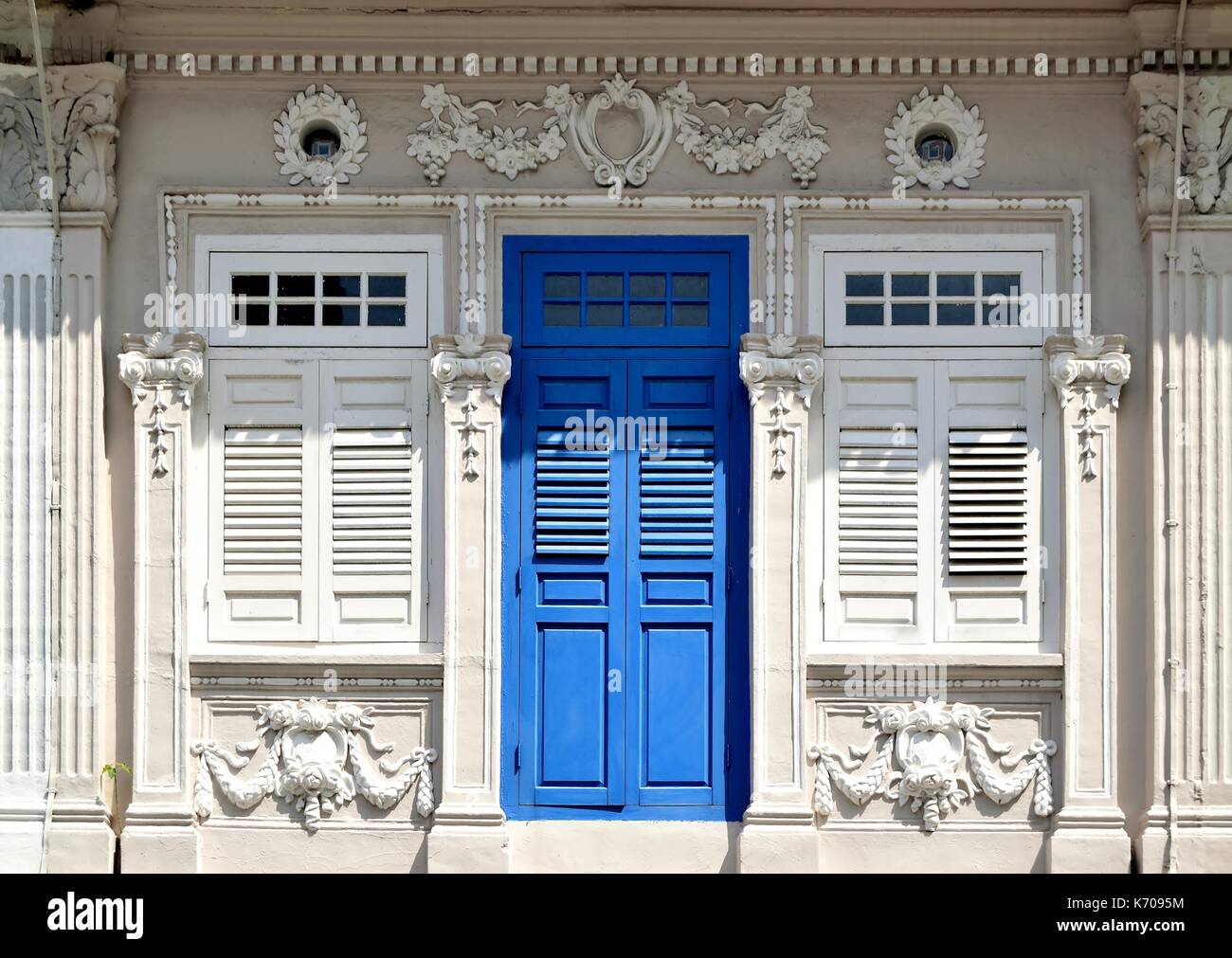 Traditional shop house exterior with cream facade, white and blue ...