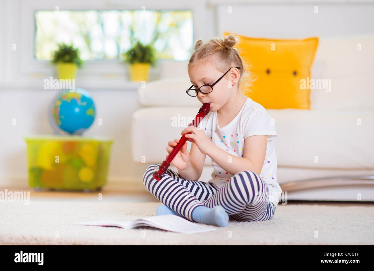 Portrait of pretty little girl with flute on floor at home Stock Photo ...