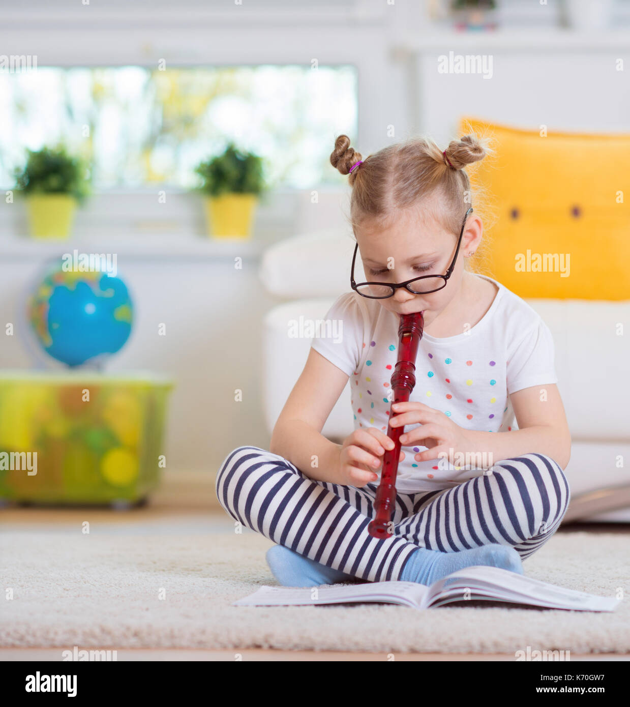 Portrait of pretty little girl with flute on floor at home Stock Photo ...
