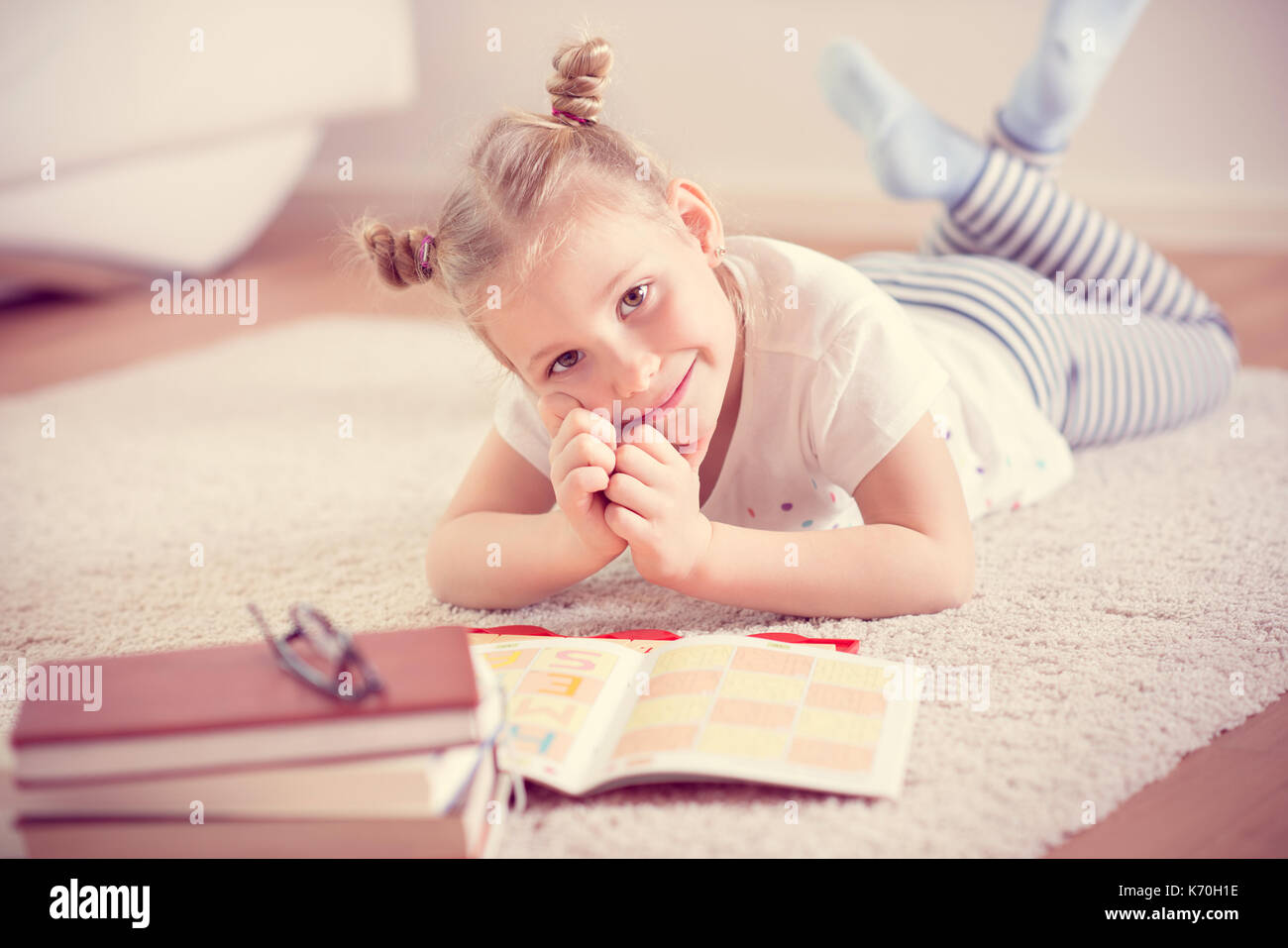 Cute little girl read book at home on floor Stock Photo - Alamy