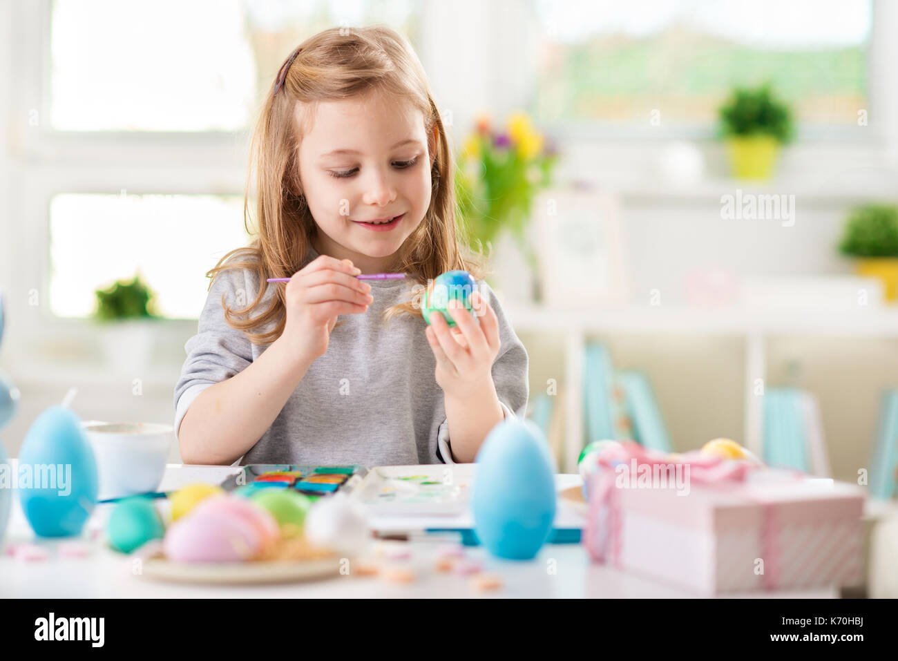 Happy pretty child girl having fun during painting eggs for Easter in ...