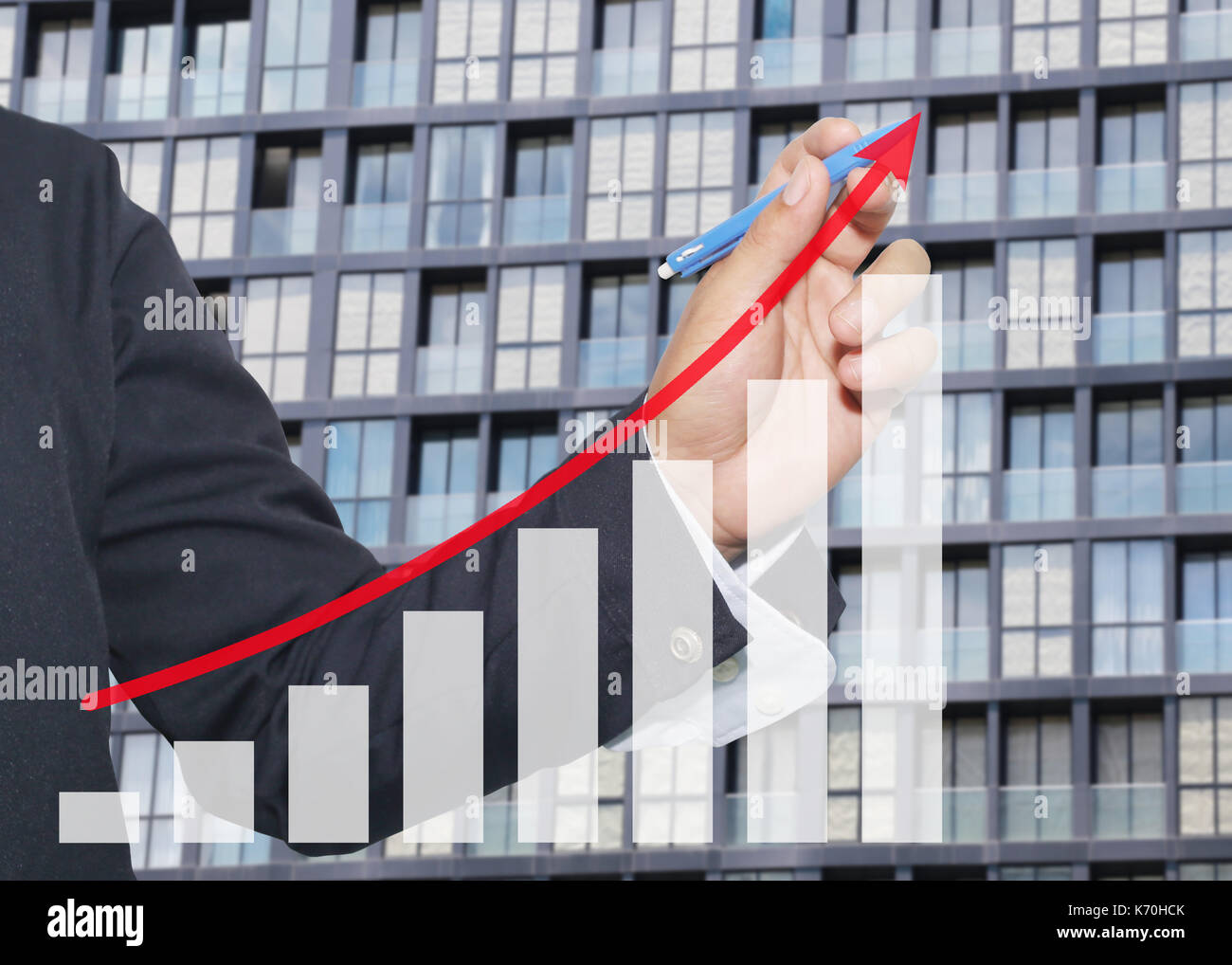 hand of businessman using blue pen pointing to top business graph on ...