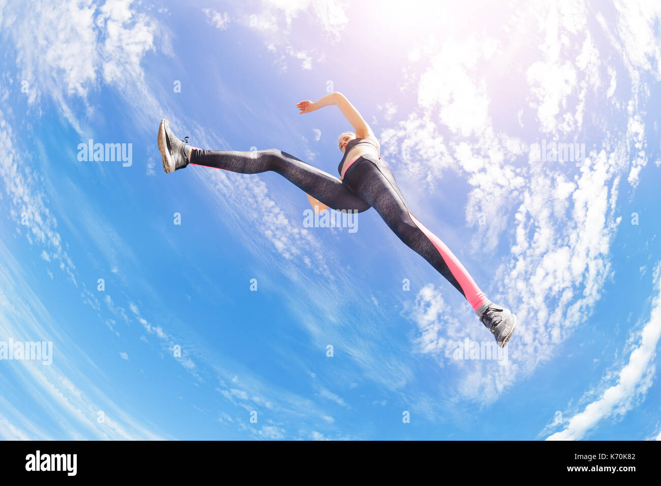 Low angle view of athlete remaining stationary in air while jumping or ...