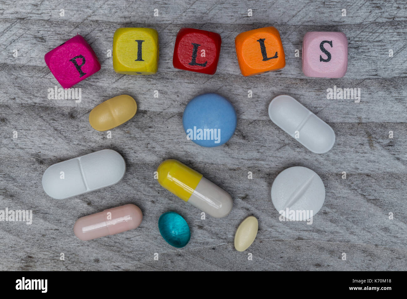 Pills letter cubes and tablets on gray wood concept Stock Photo - Alamy