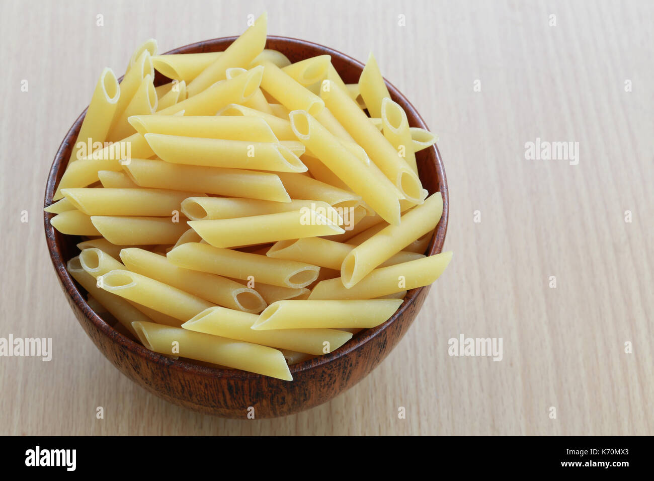 Raw Macaroni in the wooden bowl on wood background for design in your ...