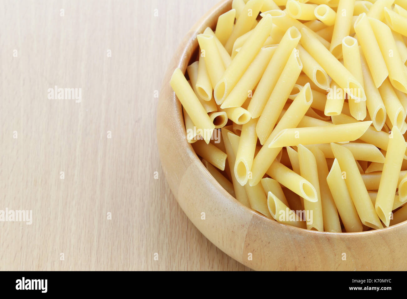 Raw Macaroni in the wooden bowl on wood background for design in your ...