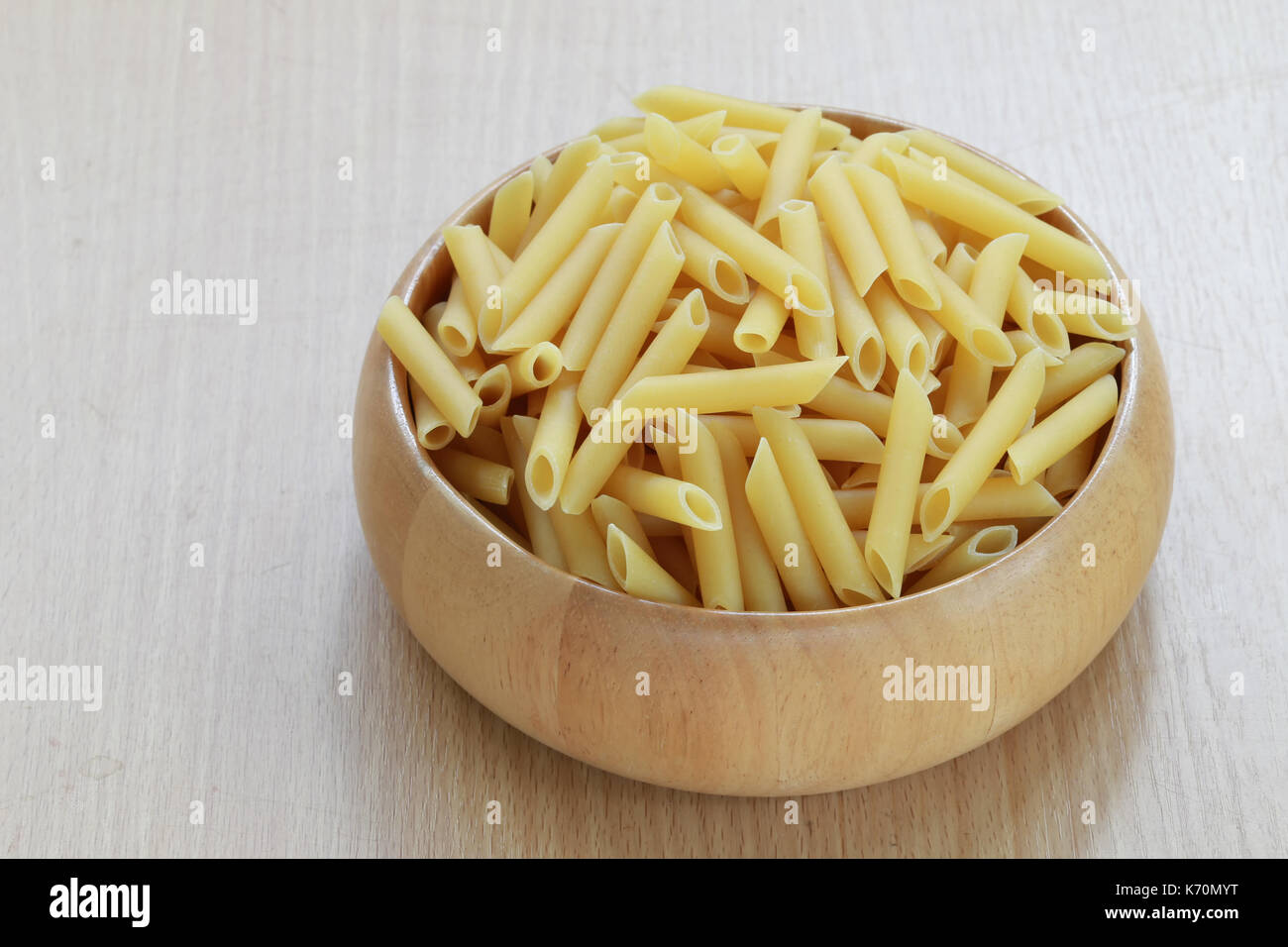 Raw Macaroni in the wooden bowl on wood background for design in your ...