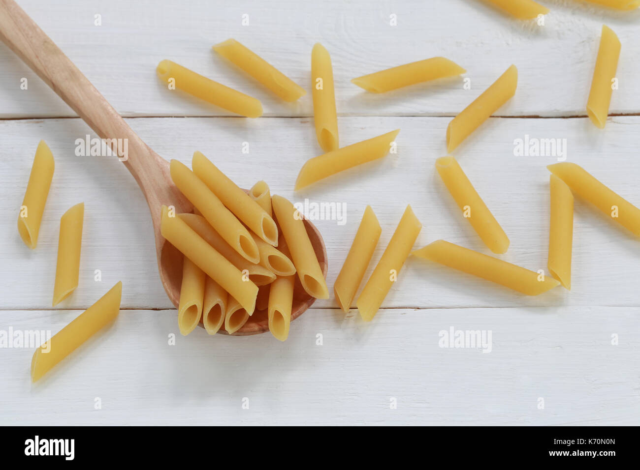 Raw Macaroni in the wooden spoon on wood background for design in your ...