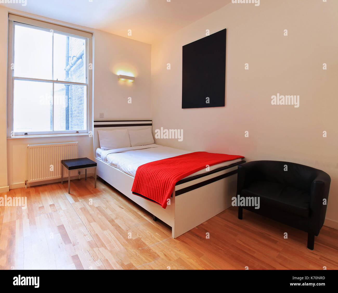 Empty room with single bed and large closed window Stock Photo - Alamy