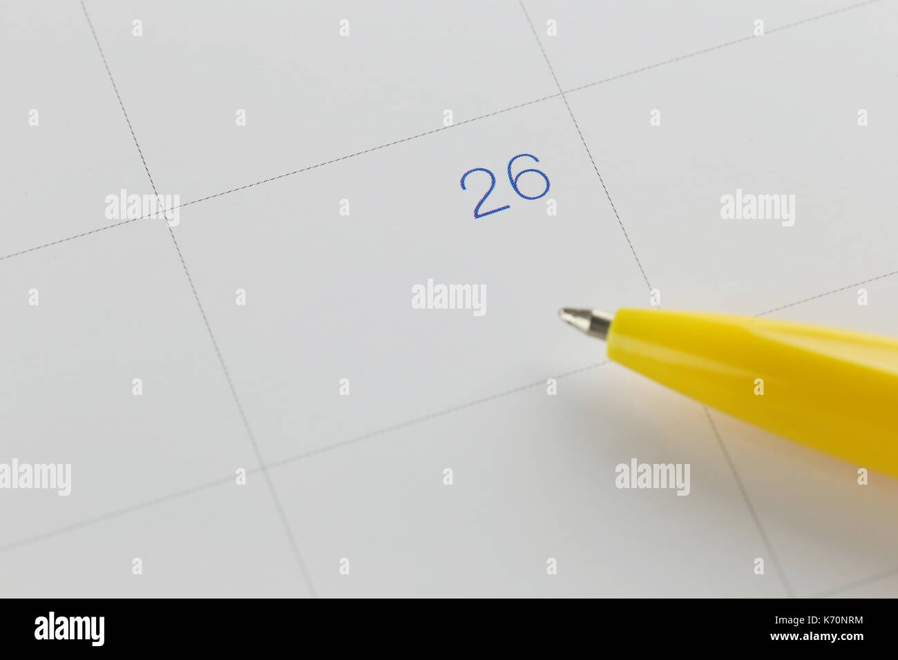 yellow pen points to the number 26 on calendar background in concept of ...