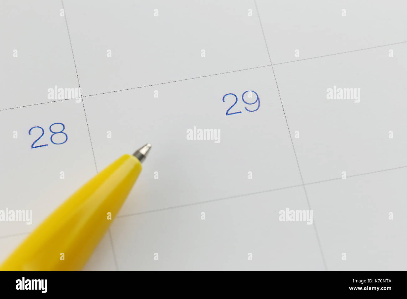 yellow pen points to the number 29 on calendar background in concept of ...