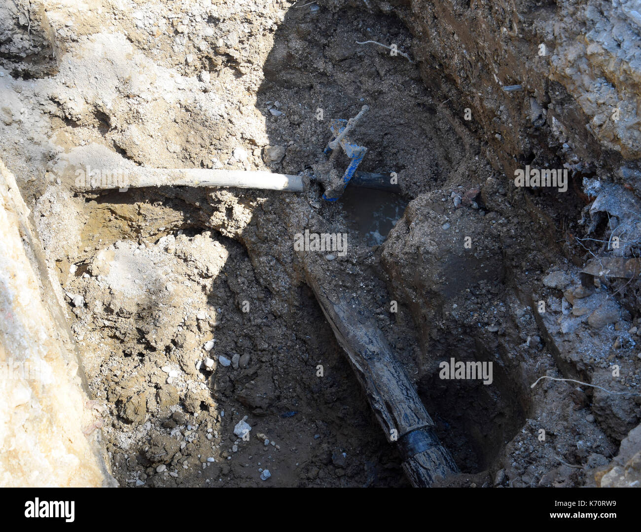 An excavated pit with a damaged pipeline. Repair of communications ...