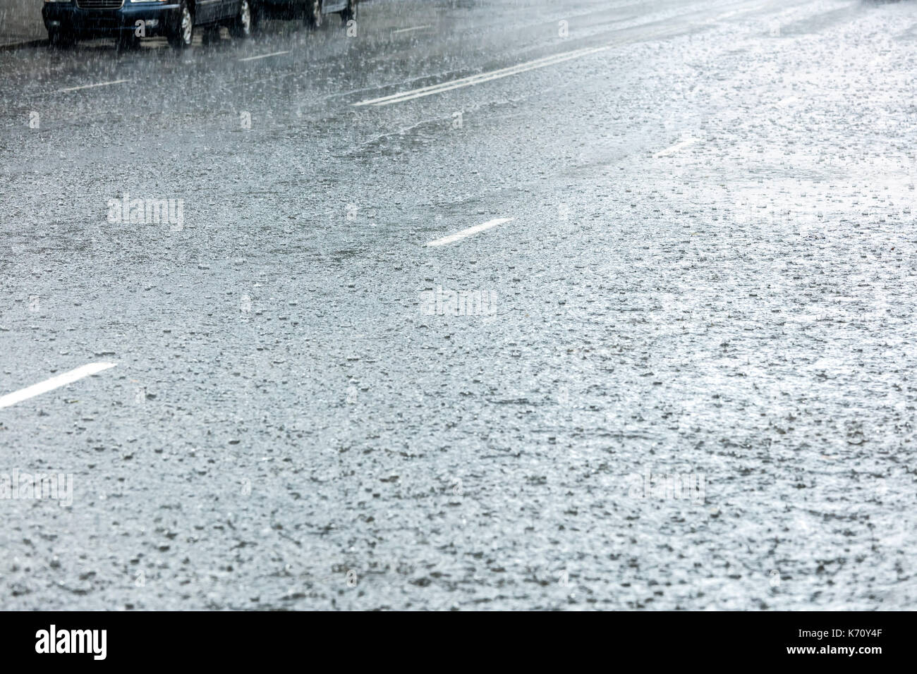 flooded asphalt road with streaming water and raindrops splashes Stock ...