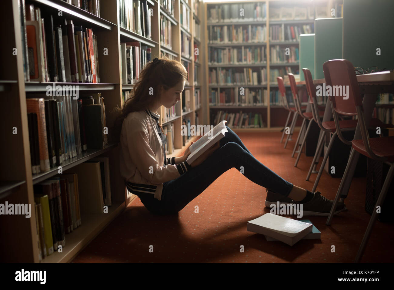 Beautiful woman reading book in library room Stock Photo - Alamy
