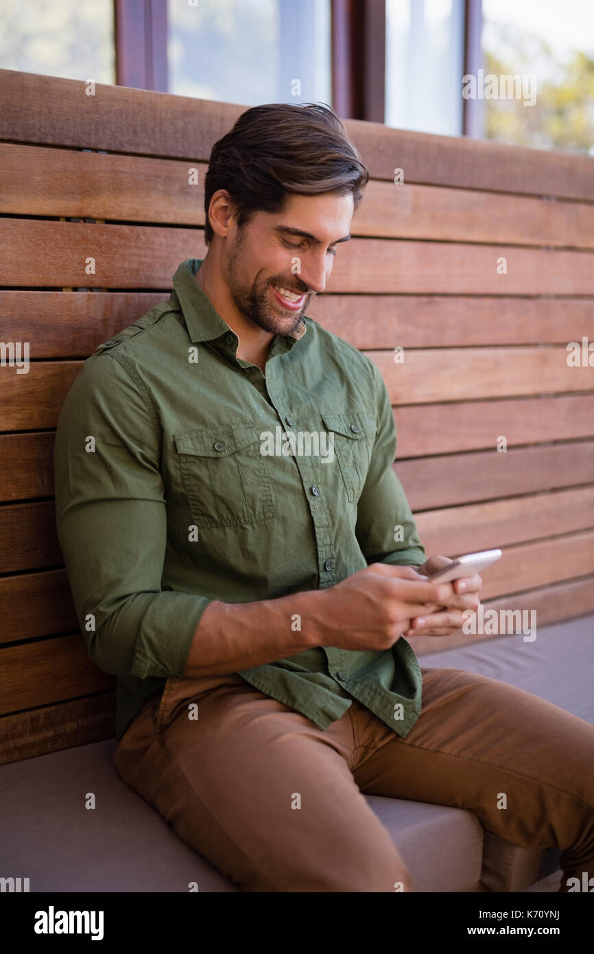 Happy man using mobile phone in cottage Stock Photo - Alamy