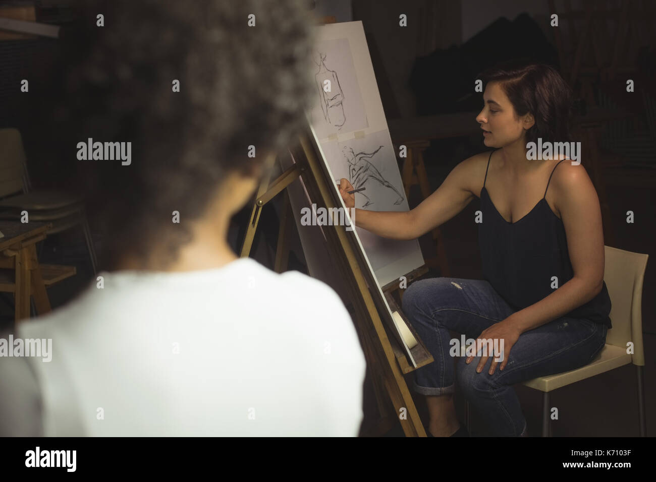 Female artist drawing a sketch of woman on canvas in art studio Stock ...