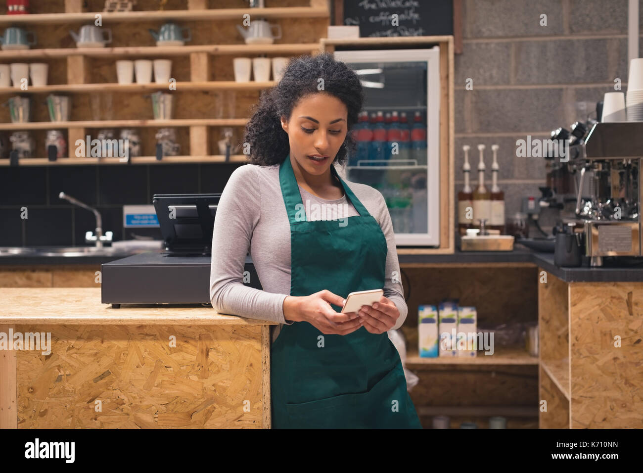 Beautiful waitress using mobile phone at counter in cafÃƒÂ© Stock Photo ...