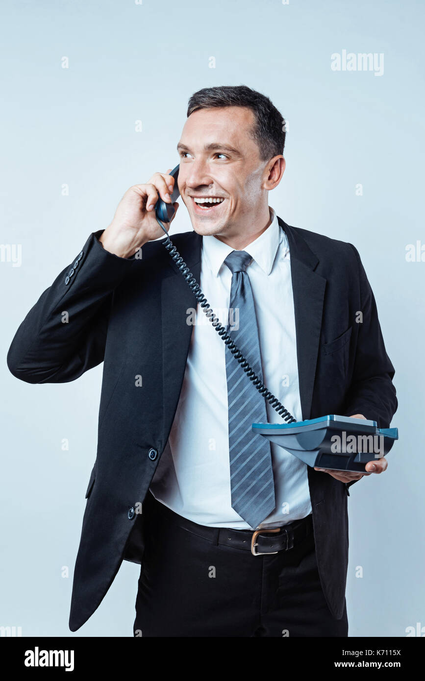 Positive minded man having pleasant telephone conversation Stock Photo ...