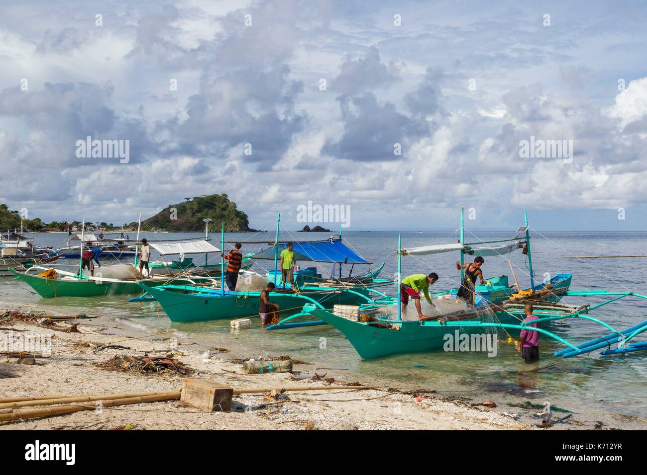 Philippines, Palawan, Calandagan Island, fishermen preparing fishnets ...