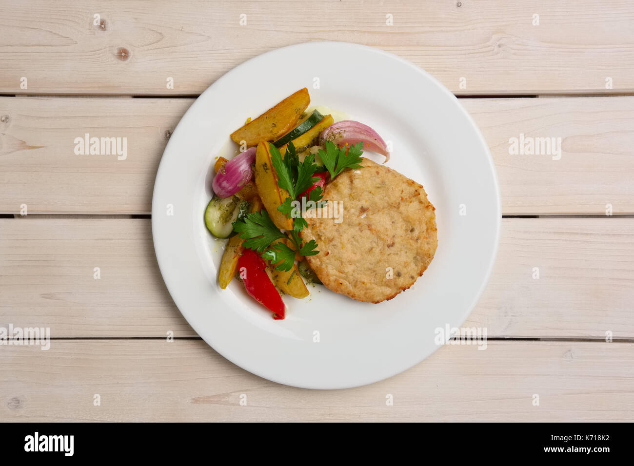 Fish cutlet with grilled potato, onion, pepper and zucchini Stock Photo ...