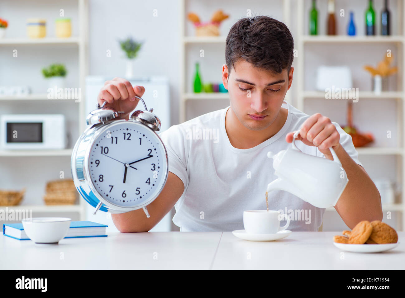 Man with alarm clock falling asleep at breakfast Stock Photo - Alamy