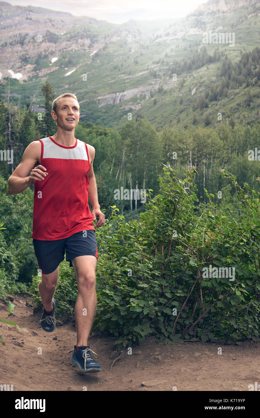 Man running up mountain trail at sunset Stock Photo - Alamy