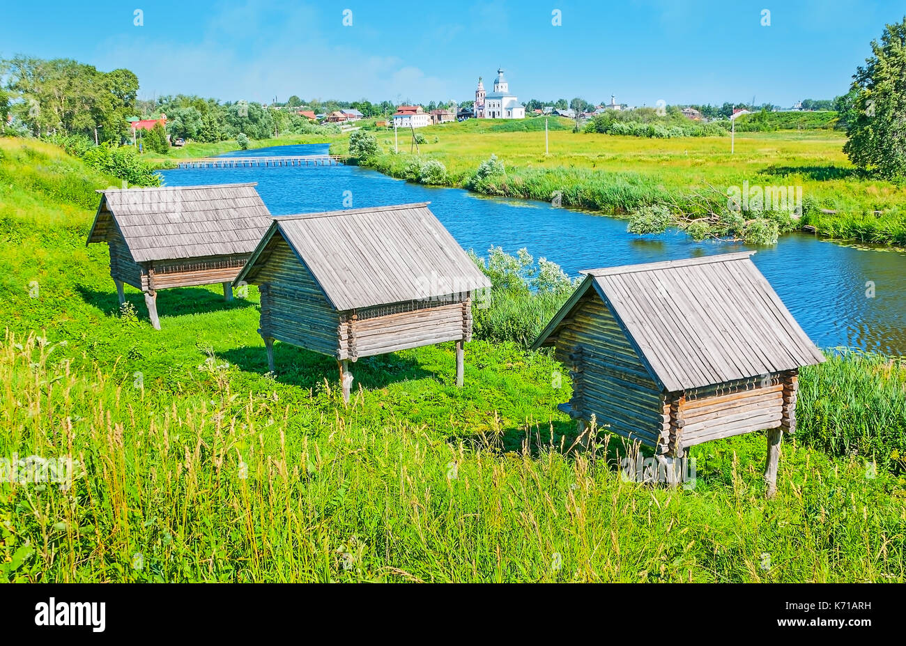 The old wooden barns on stilts, located on the green bank of Kamenka ...