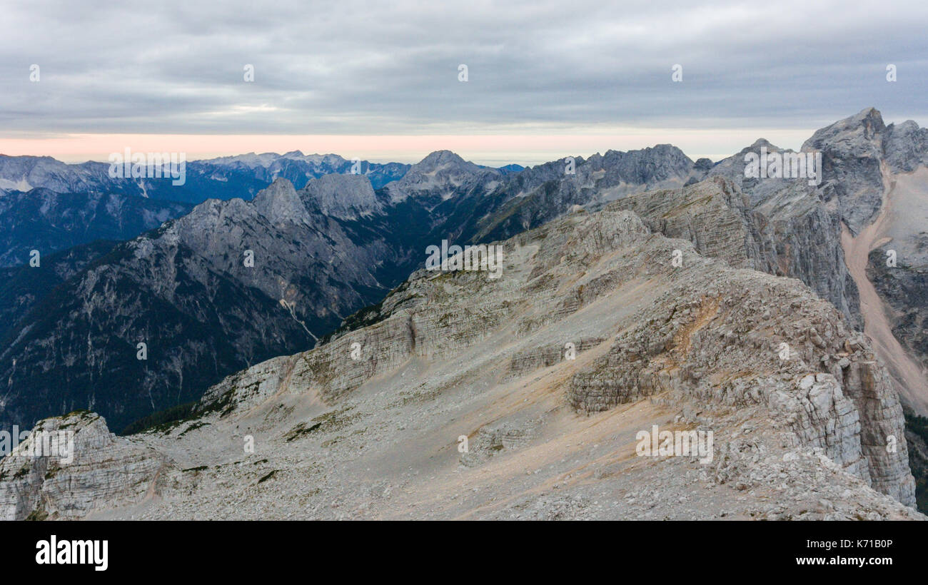 Sheer mountain cliff with slope on one side Stock Photo - Alamy