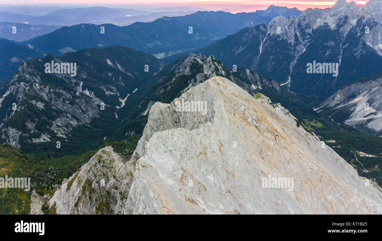 Sheer mountain cliff with slope on one side Stock Photo - Alamy