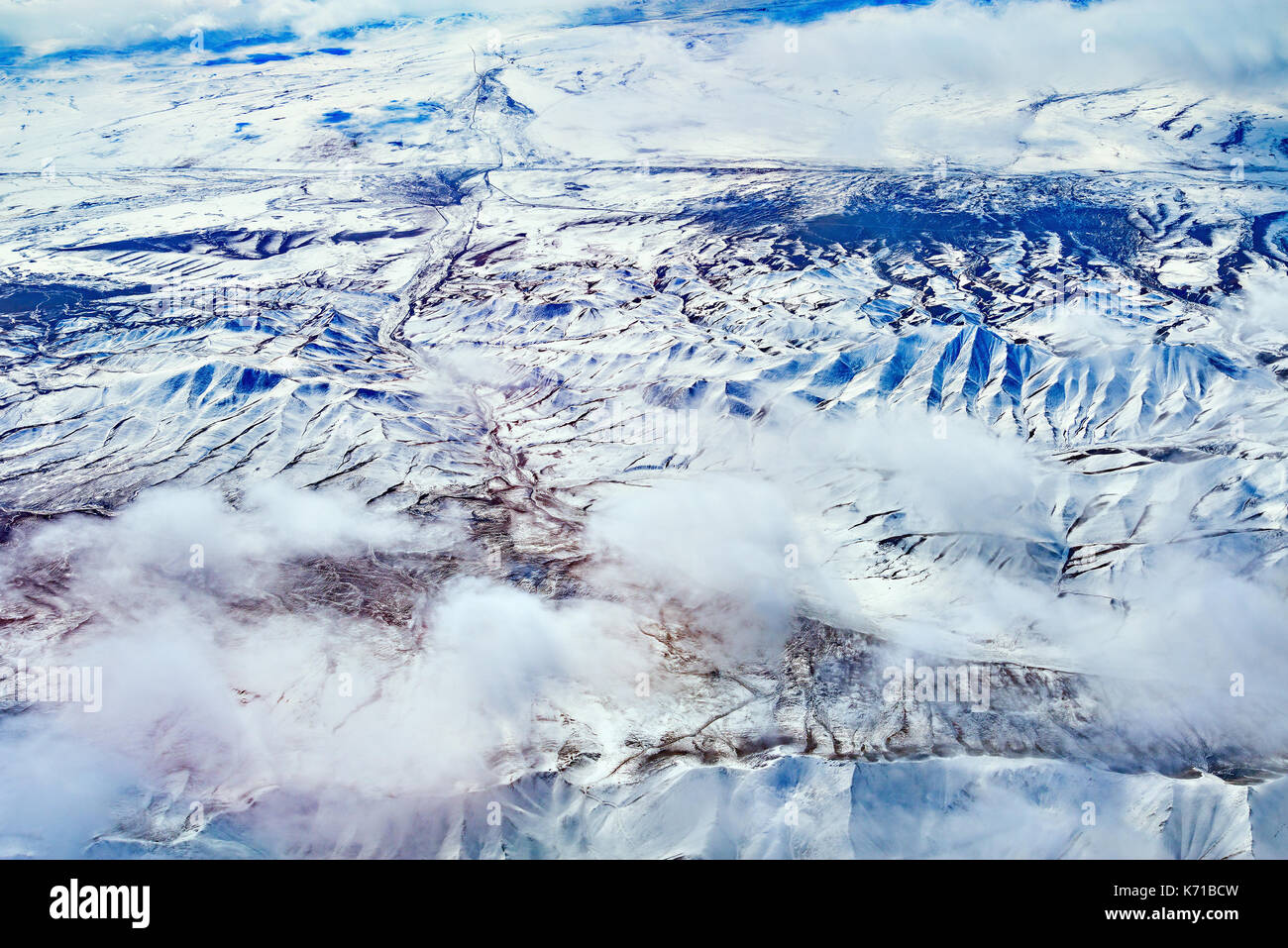 Mountain landscape under the clouds. View from the airplane window ...
