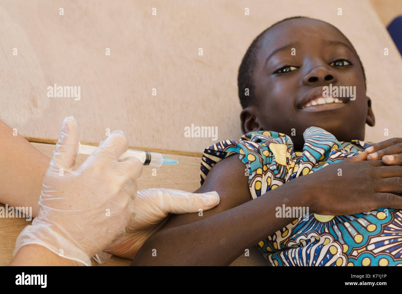 Black boy smiles ready to get his first needle injection from a ...