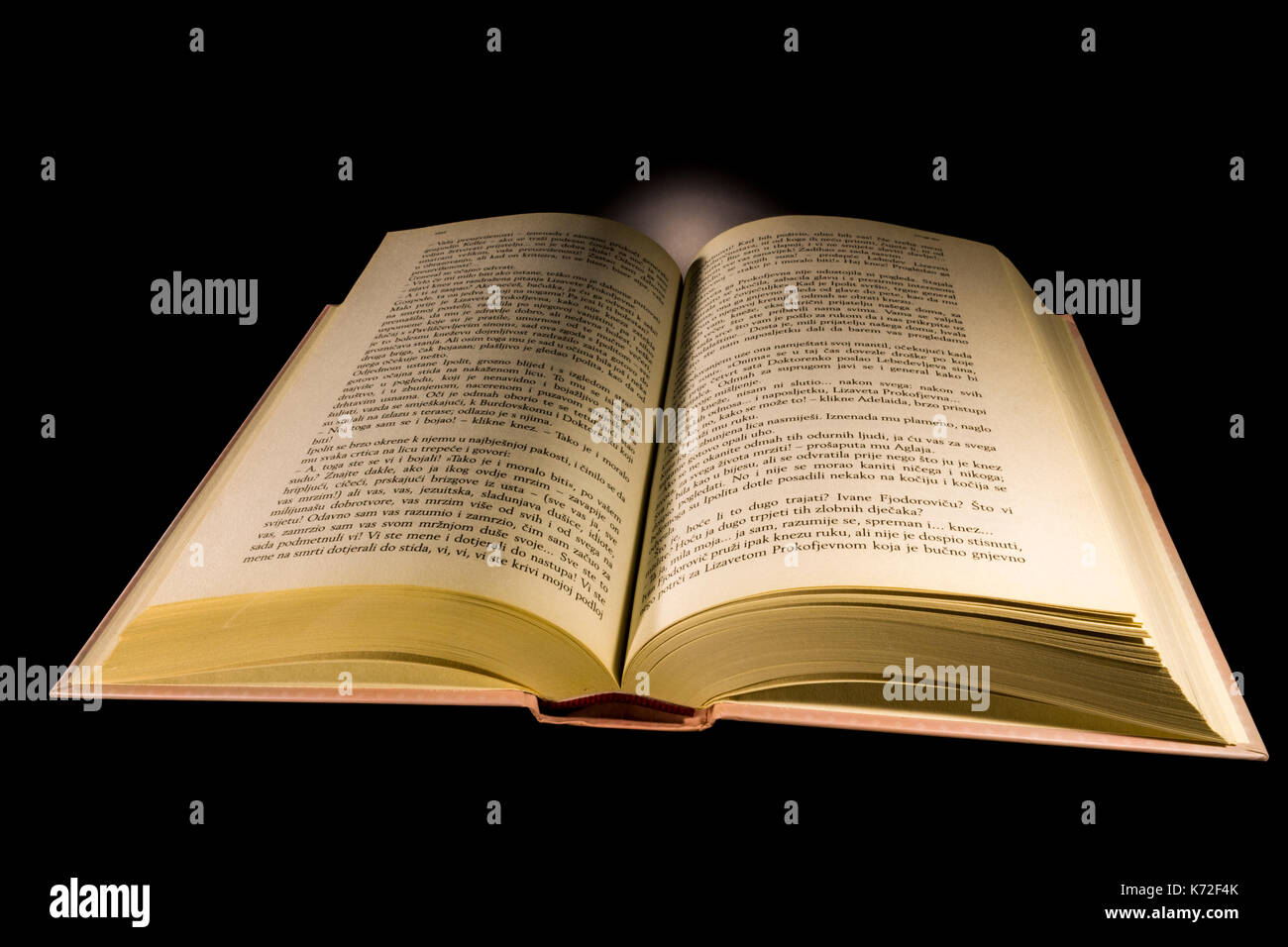 Open book on a black background Stock Photo - Alamy