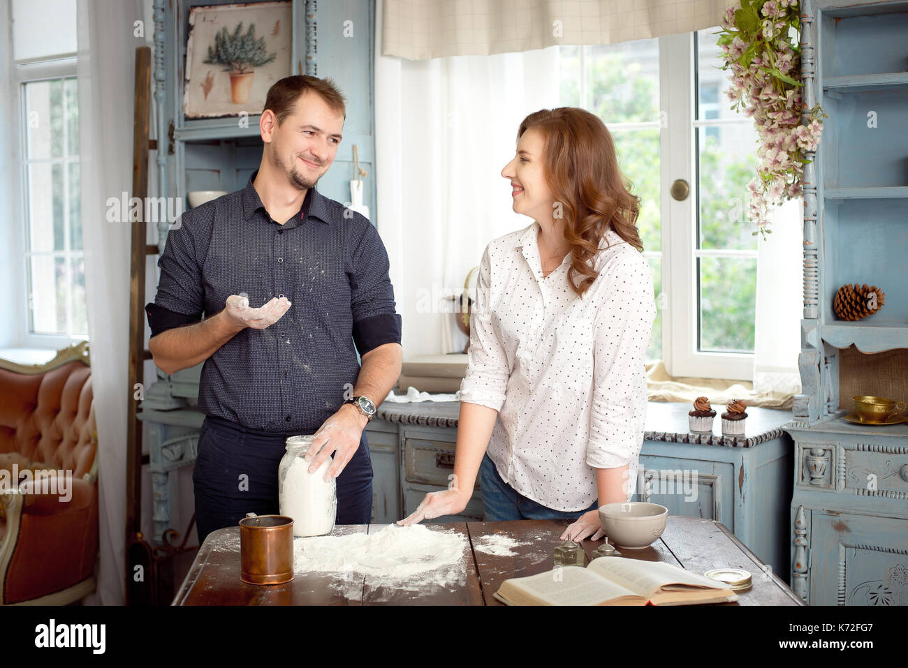 Young couple in the kitchen playing with flour. Funny moments, smiles ...