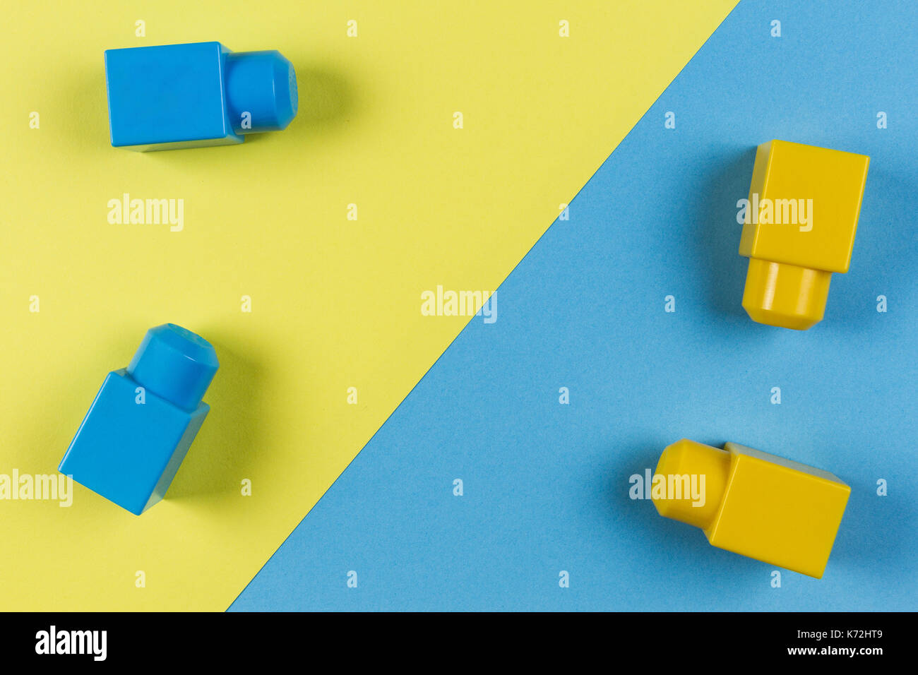 Blue and yellow plastic construction blocks on yellow and blue ...