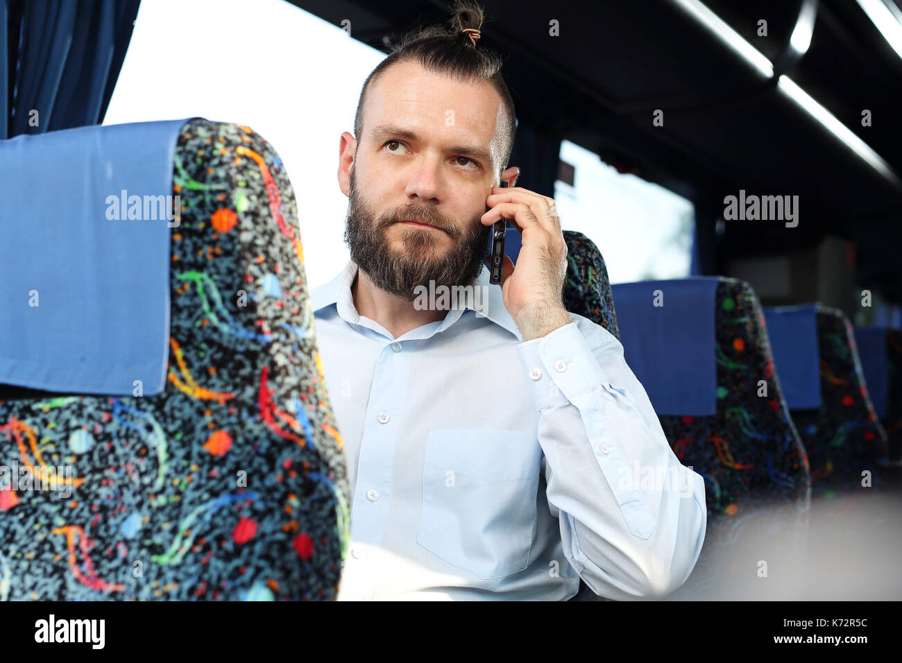 Passenger in the coach. Coach trip. Passenger speaks on the phone while ...