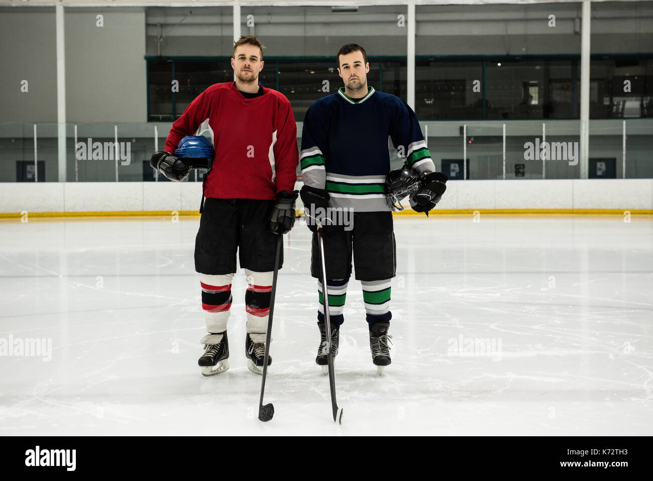 Portrait of male ice hockey players with helmets standing at rink Stock ...