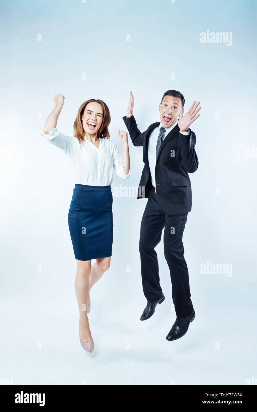 Emotional colleagues getting excited together over background Stock ...