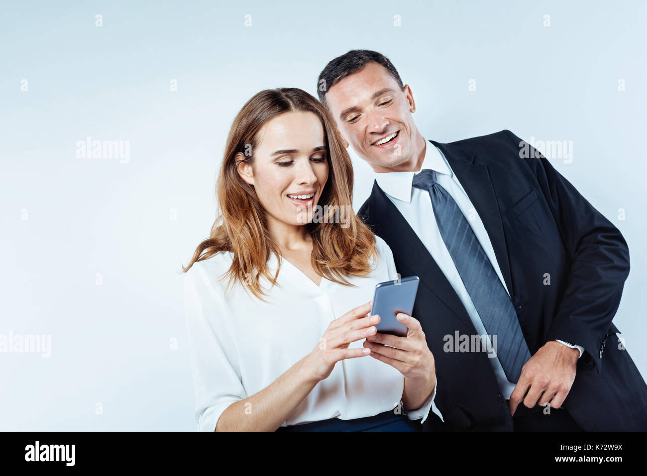 Friendly colleagues sharing photos on smartphone Stock Photo - Alamy