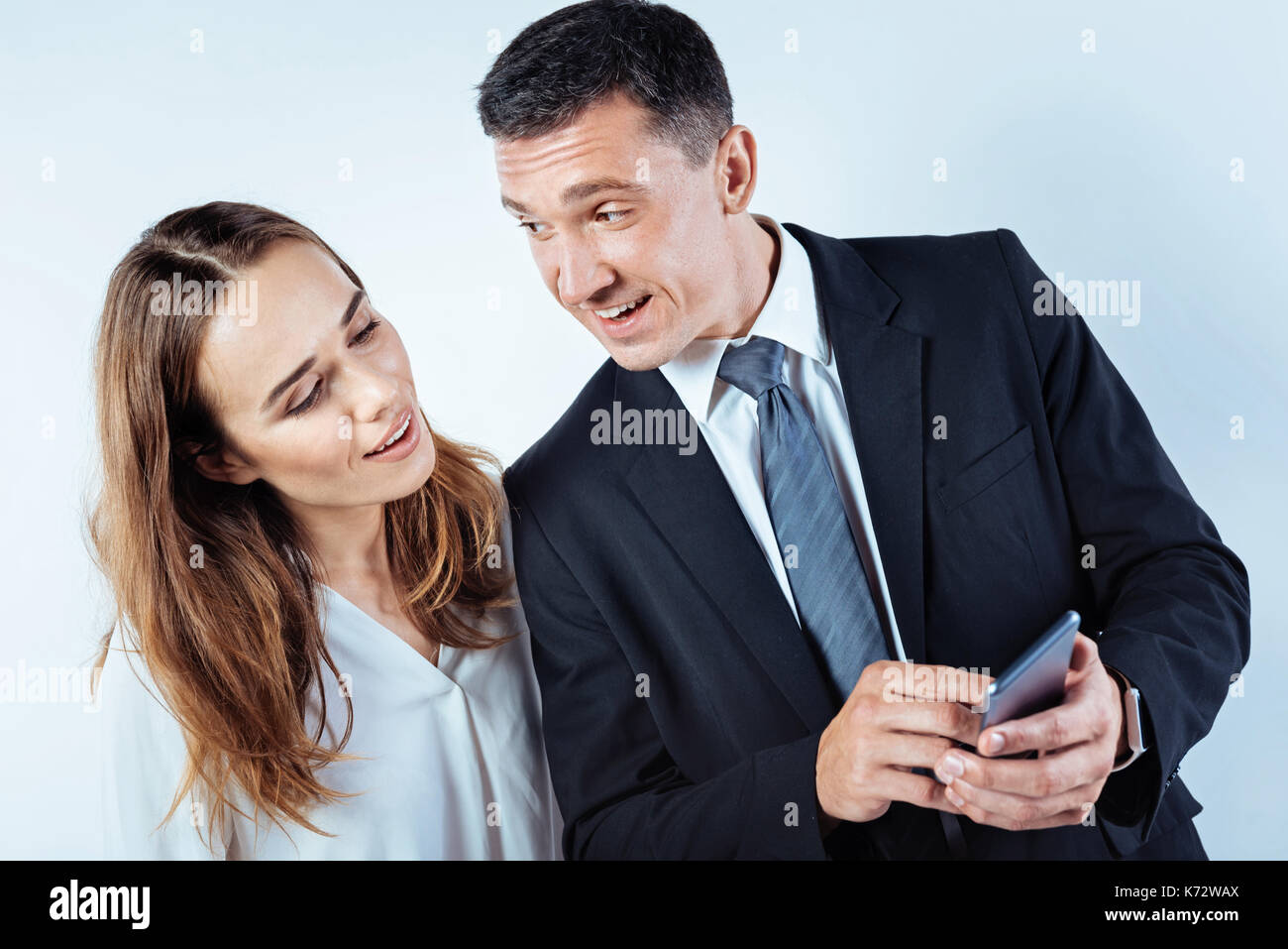 Relaxed colleagues talking over something together Stock Photo - Alamy
