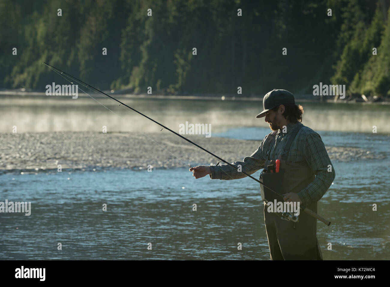 Man adjusting reel fishing hi-res stock photography and images - Alamy