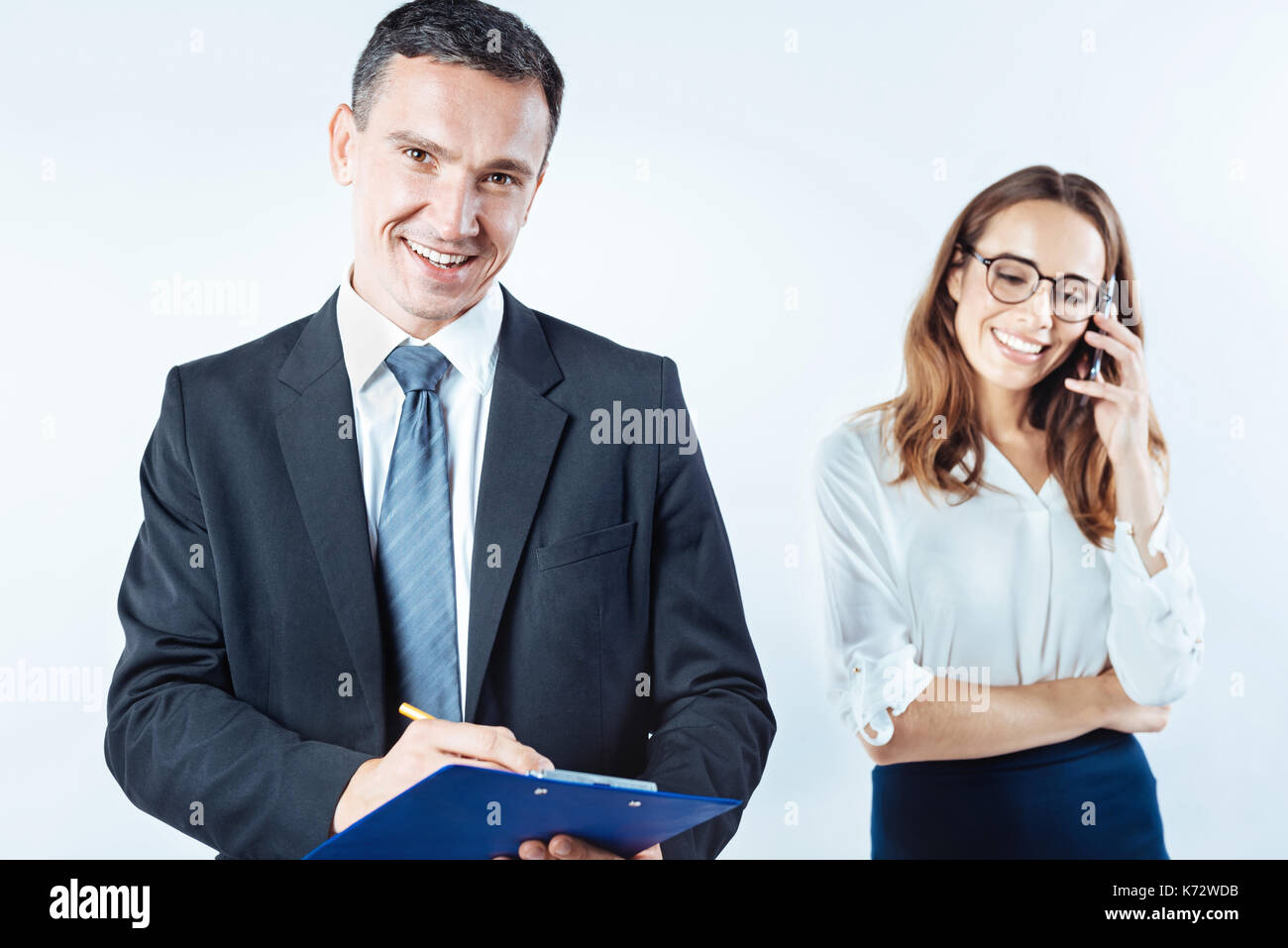 Cheerful man taking notes on clipboard Stock Photo - Alamy
