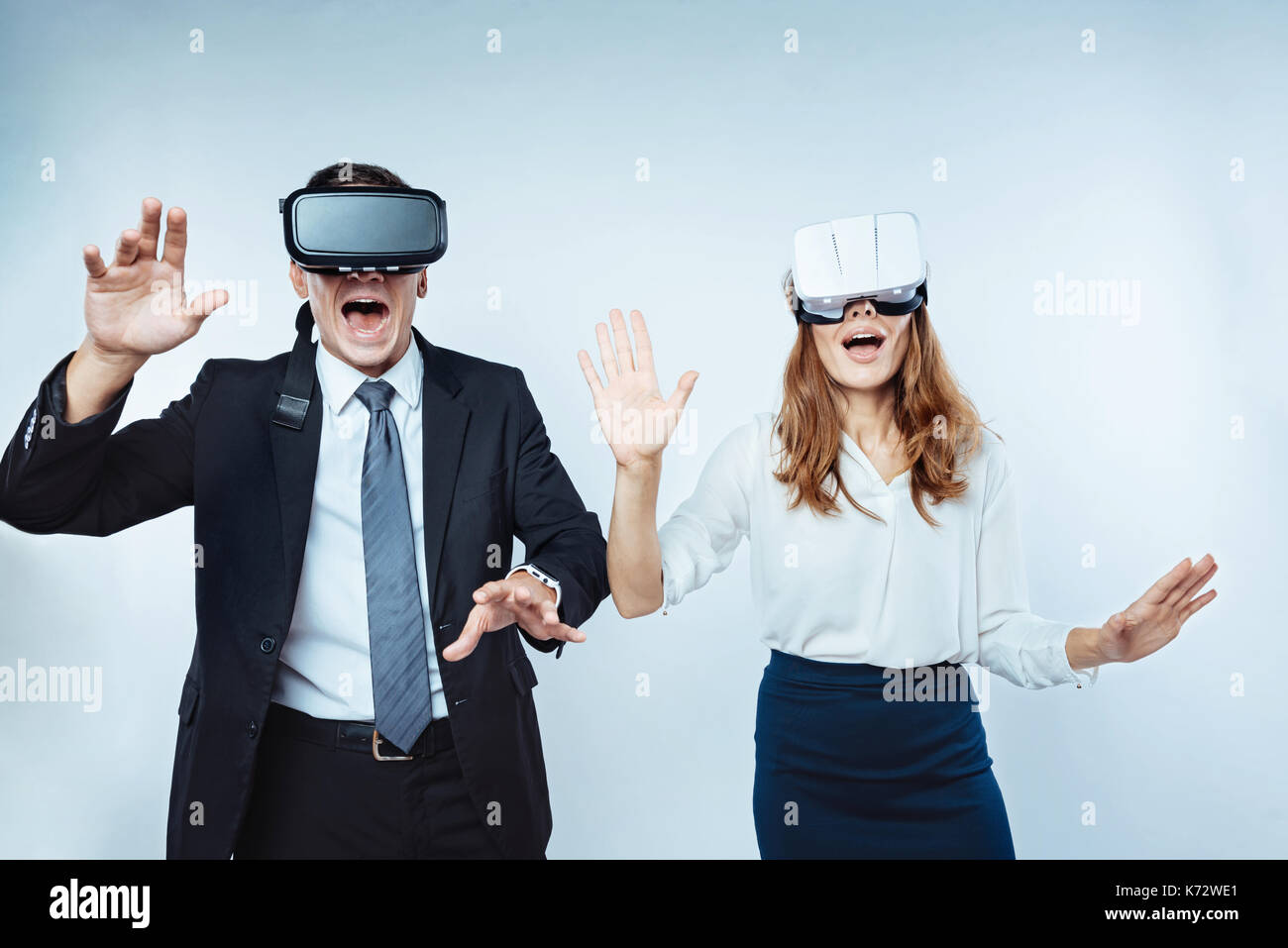 Emotional business people trying on VR headset Stock Photo - Alamy