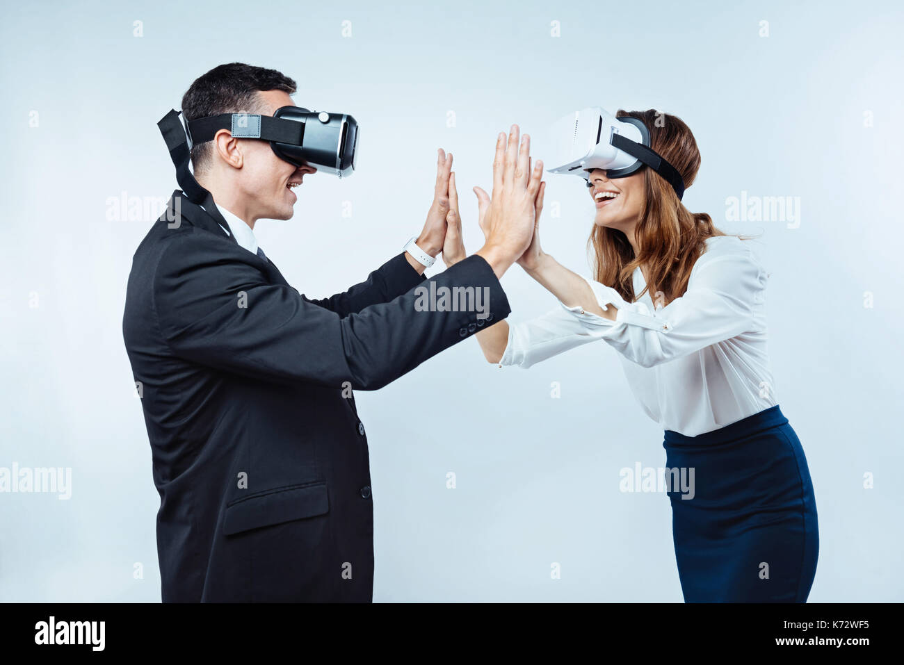 Happy business people high fiving together Stock Photo - Alamy